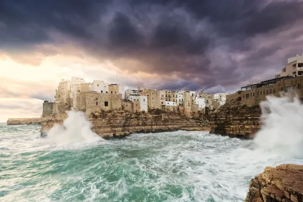 Waves crash on the cliff during a winter storm at sunrise